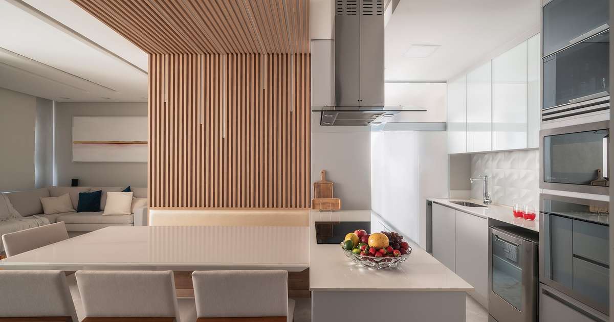 Ripas no teto e jardim vertical marcam a área social deste apê de 68m²