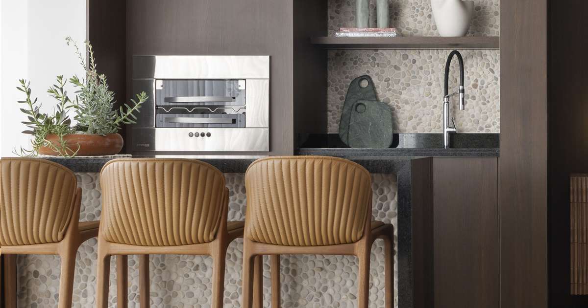 Sofá ilha é ponto central da sala de apê de 135m² com área gourmet