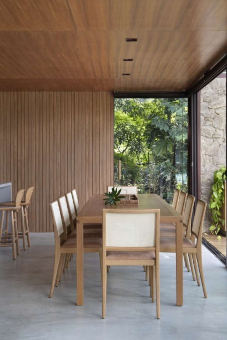 Painéis lisos e ripados de madeira freijó revestem casa de campo de 300m²