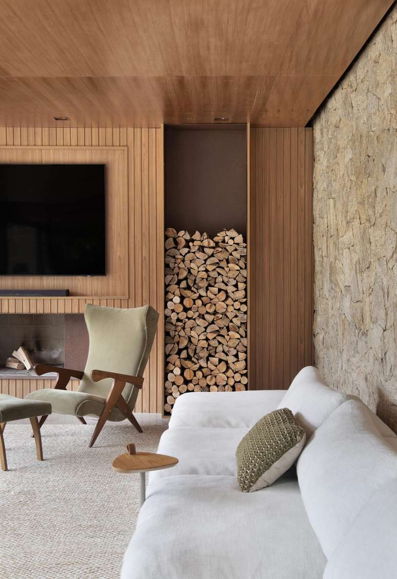 Painéis lisos e ripados de madeira freijó revestem casa de campo de 300m²